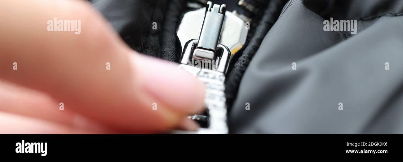Hand fastens the zipper on jacket closeup Stock Photo - Alamy