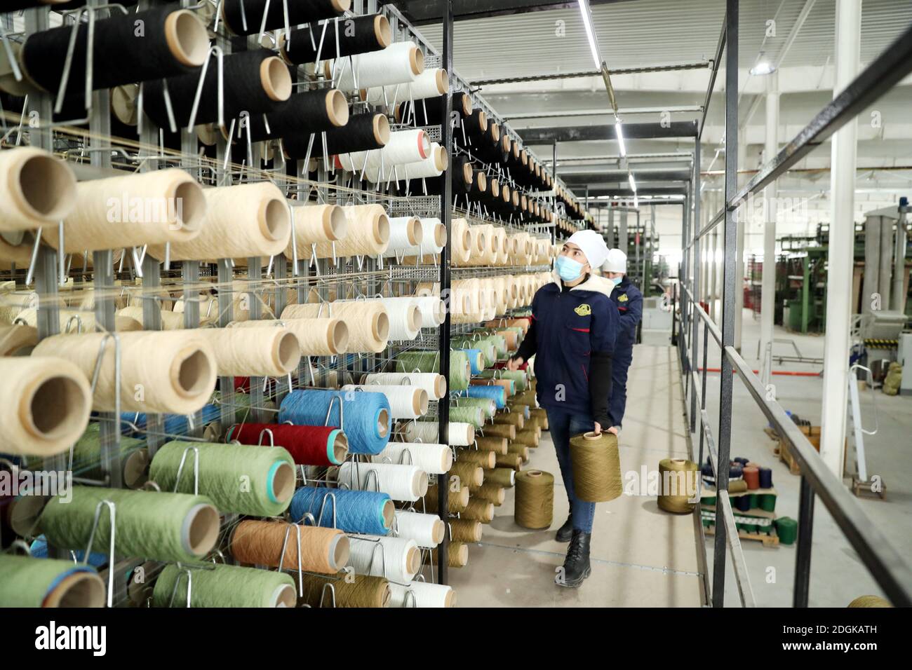 Local workers, standing along the production line, are busy at ...
