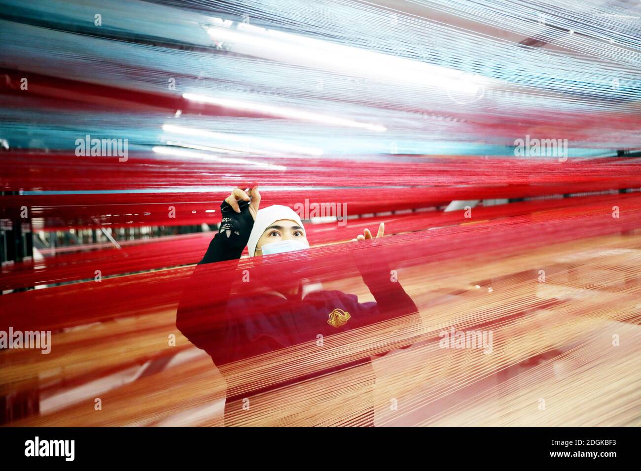 Local workers, standing along the production line, are busy at ...