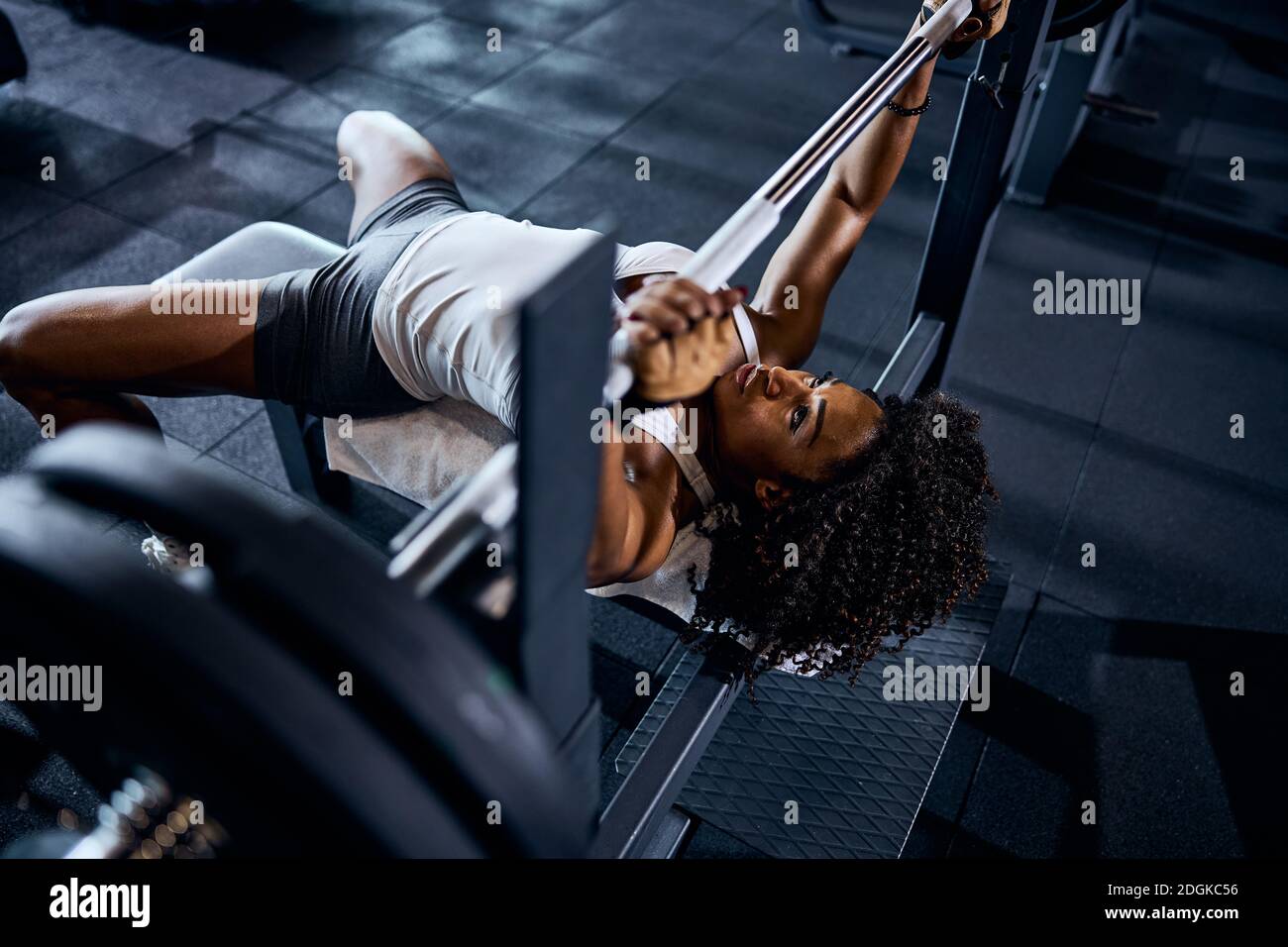 Serene strong sportswoman lifting the loaded barbell Stock Photo - Alamy