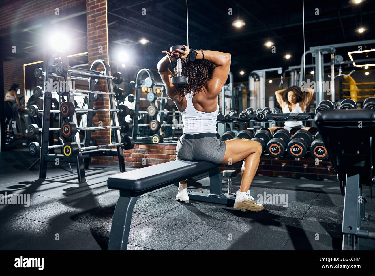 Dark-haired young woman performing a strength exercise Stock Photo - Alamy