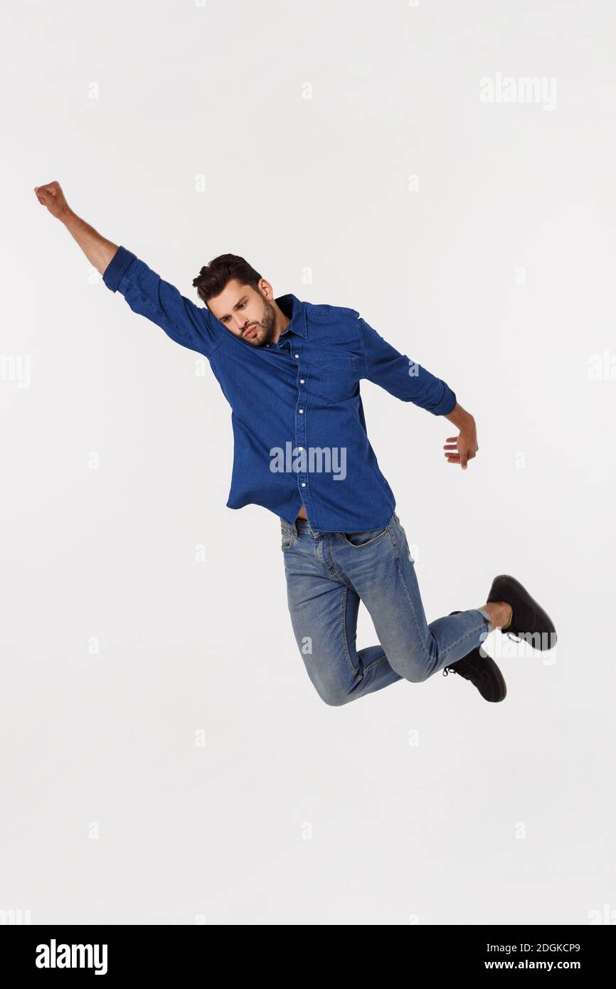 An attractive athletic businessman jumping up against white background ...