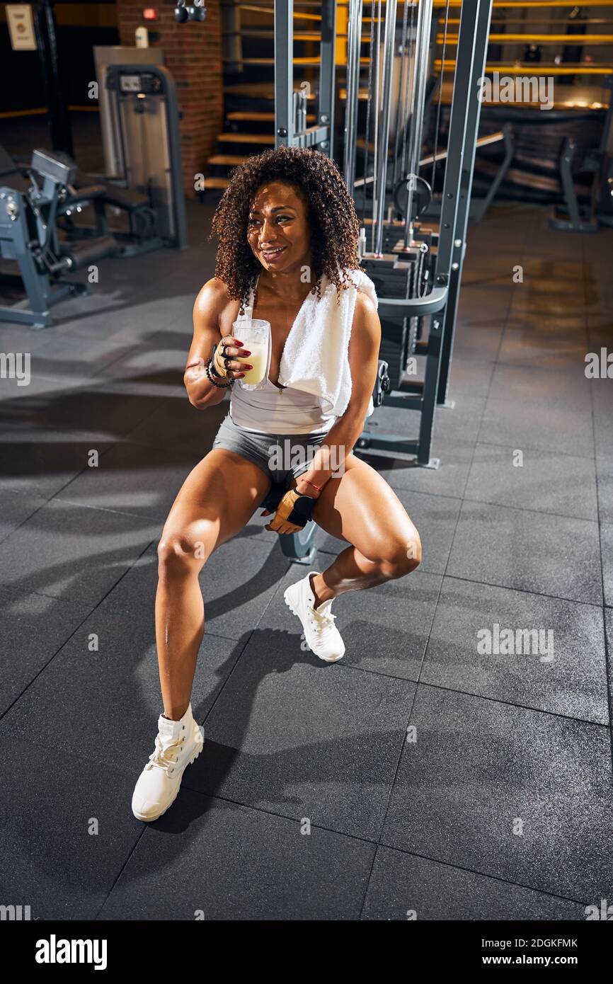 Cheerful woman with a protein shake looking away Stock Photo - Alamy