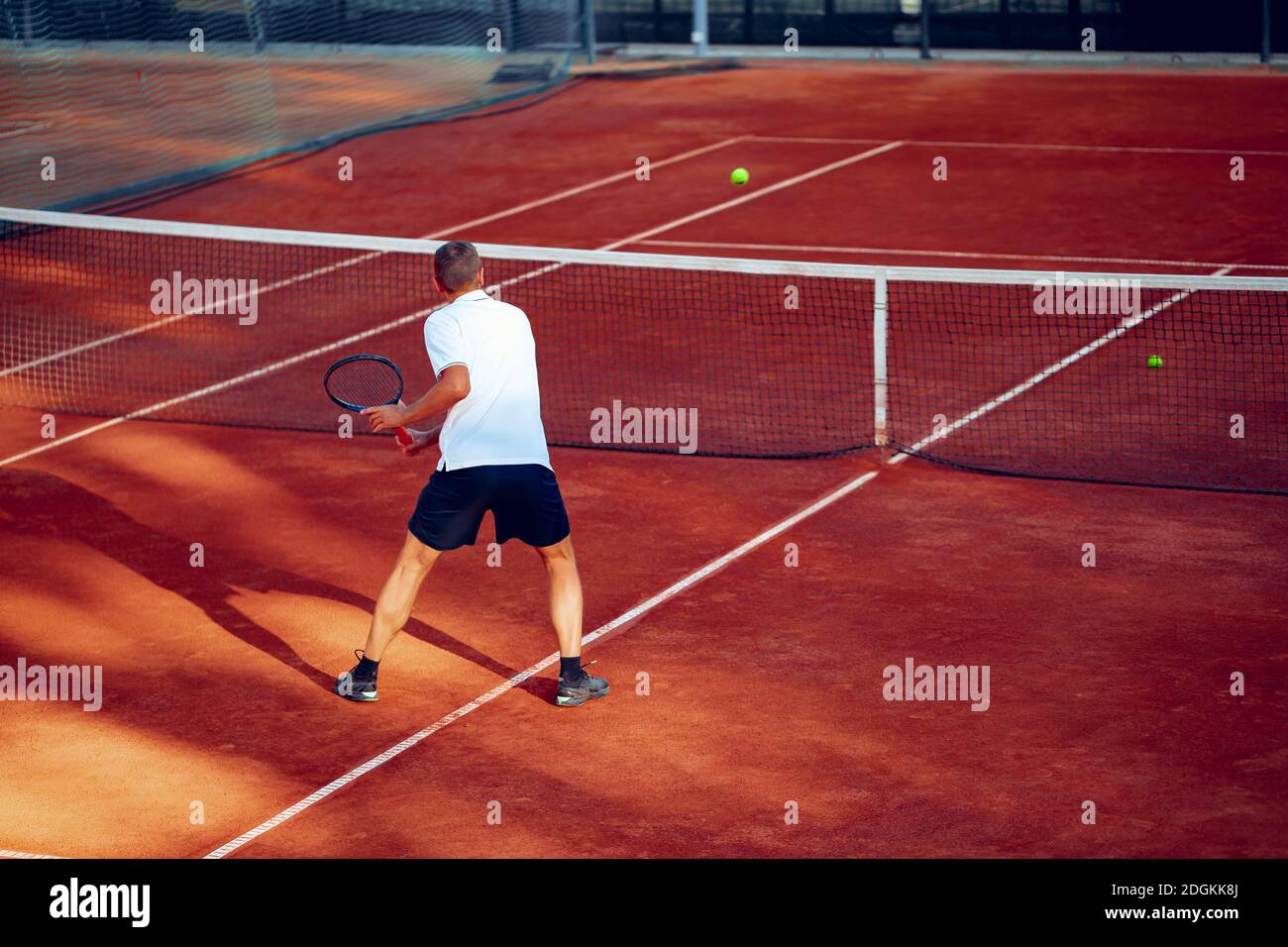 Back view of a man playing tennis on tennis court Stock Photo - Alamy