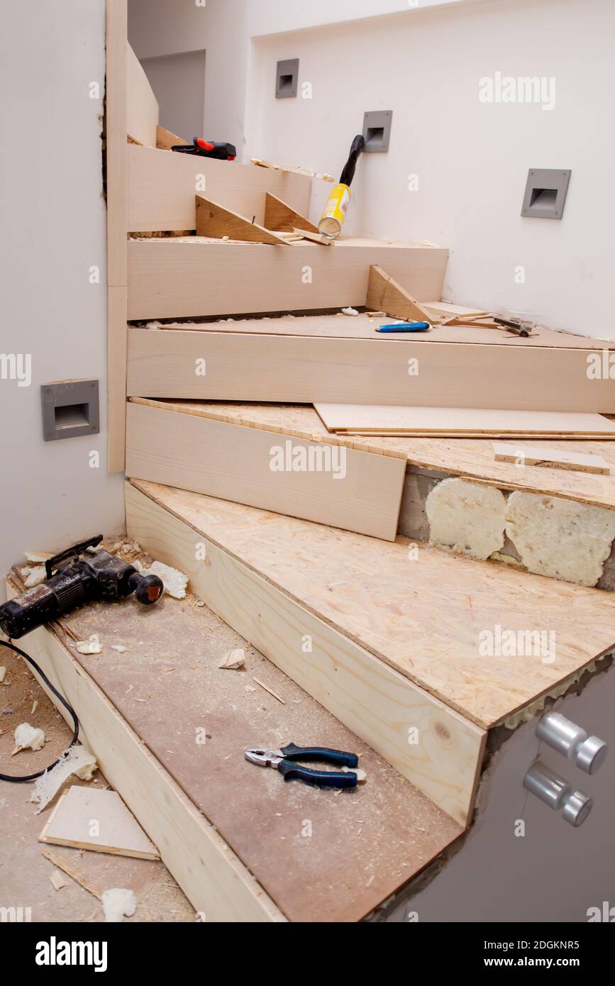 Work in progress on stylish interior with wooden stairs Stock Photo - Alamy