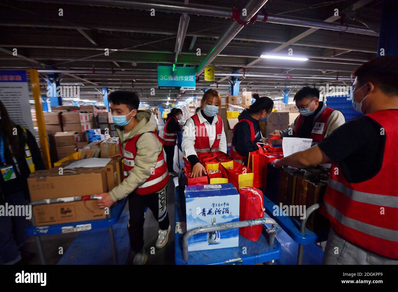 Staff line up to sort piles of deliveries on the Double Eleven Shopping Festival at a Sunning ...