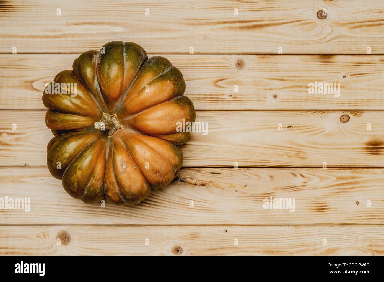One whole pumpkin on wooden table background Stock Photo - Alamy