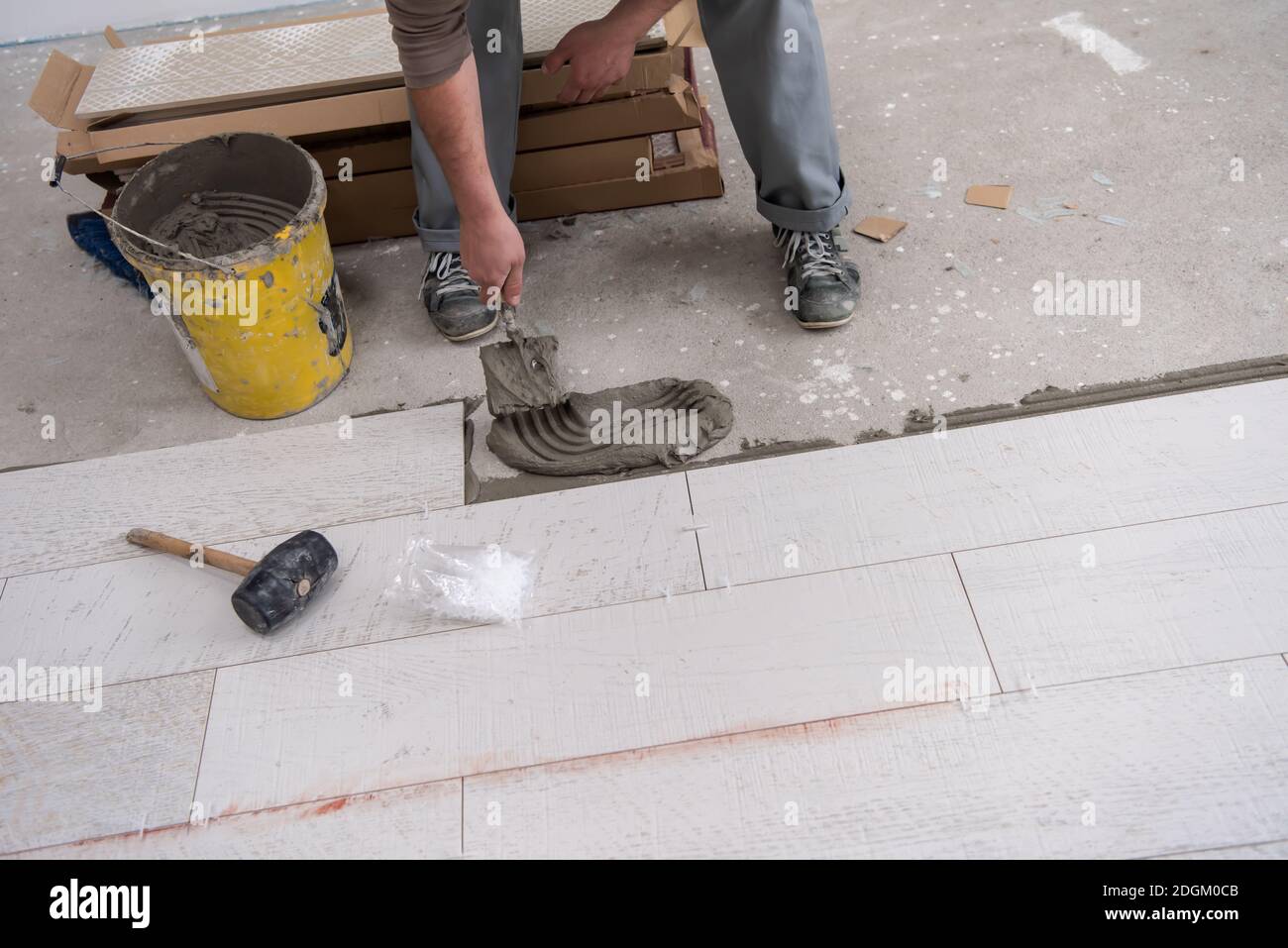 Worker installing the ceramic wood effect tiles on the floor Stock ...