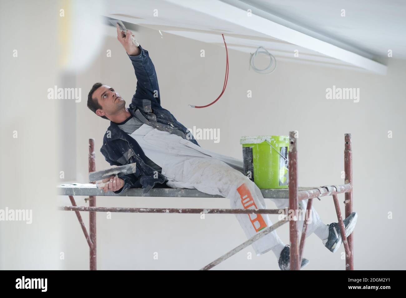 Construction worker plastering on gypsum ceiling Stock Photo - Alamy