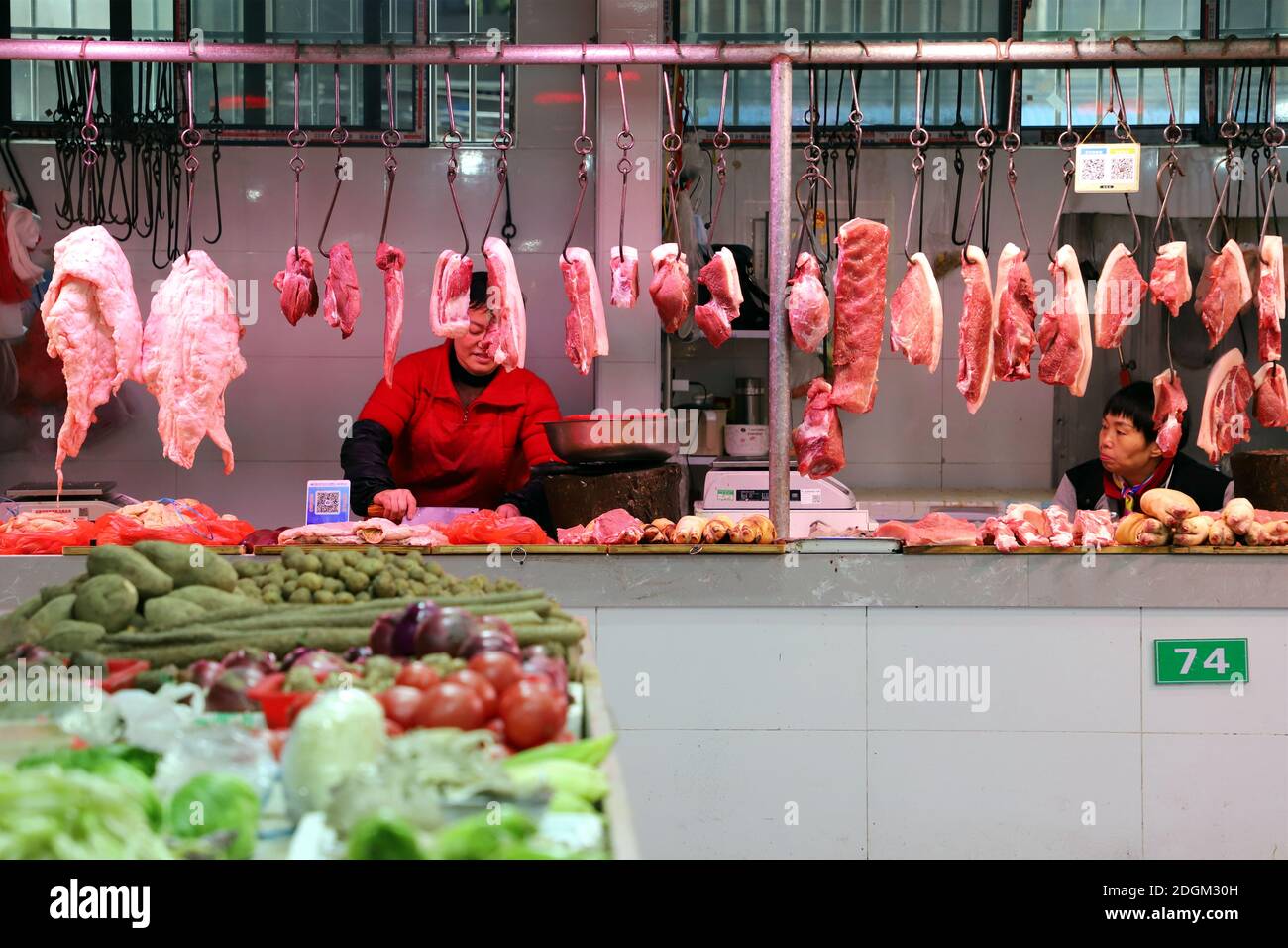A vendor sells meat at a food market in Yichang city, south China's ...