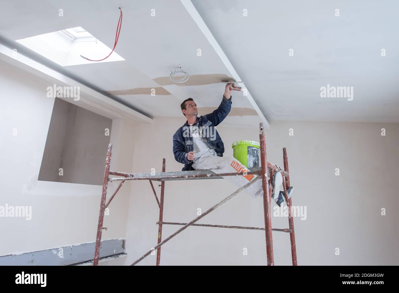 Construction worker plastering on gypsum ceiling Stock Photo - Alamy