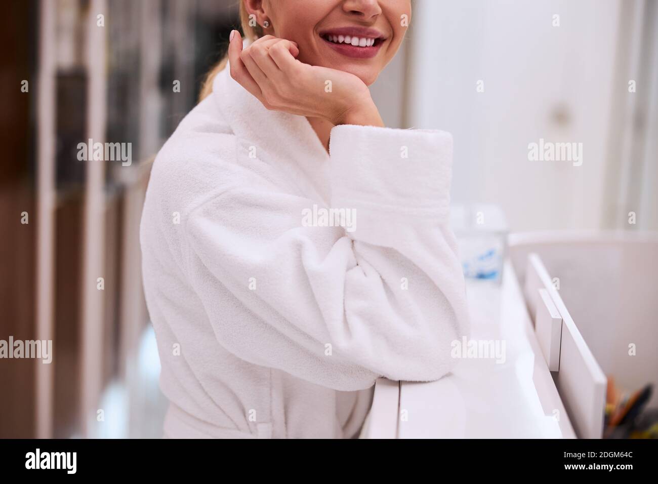 Spa client in a bathrobe waiting at the inquiry counter Stock Photo - Alamy