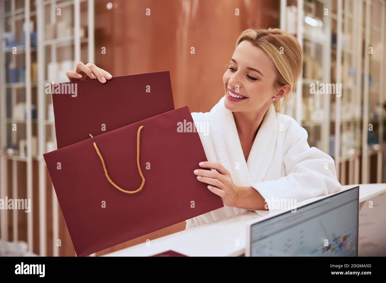 Happy client looking at her present in a wellness center Stock Photo ...