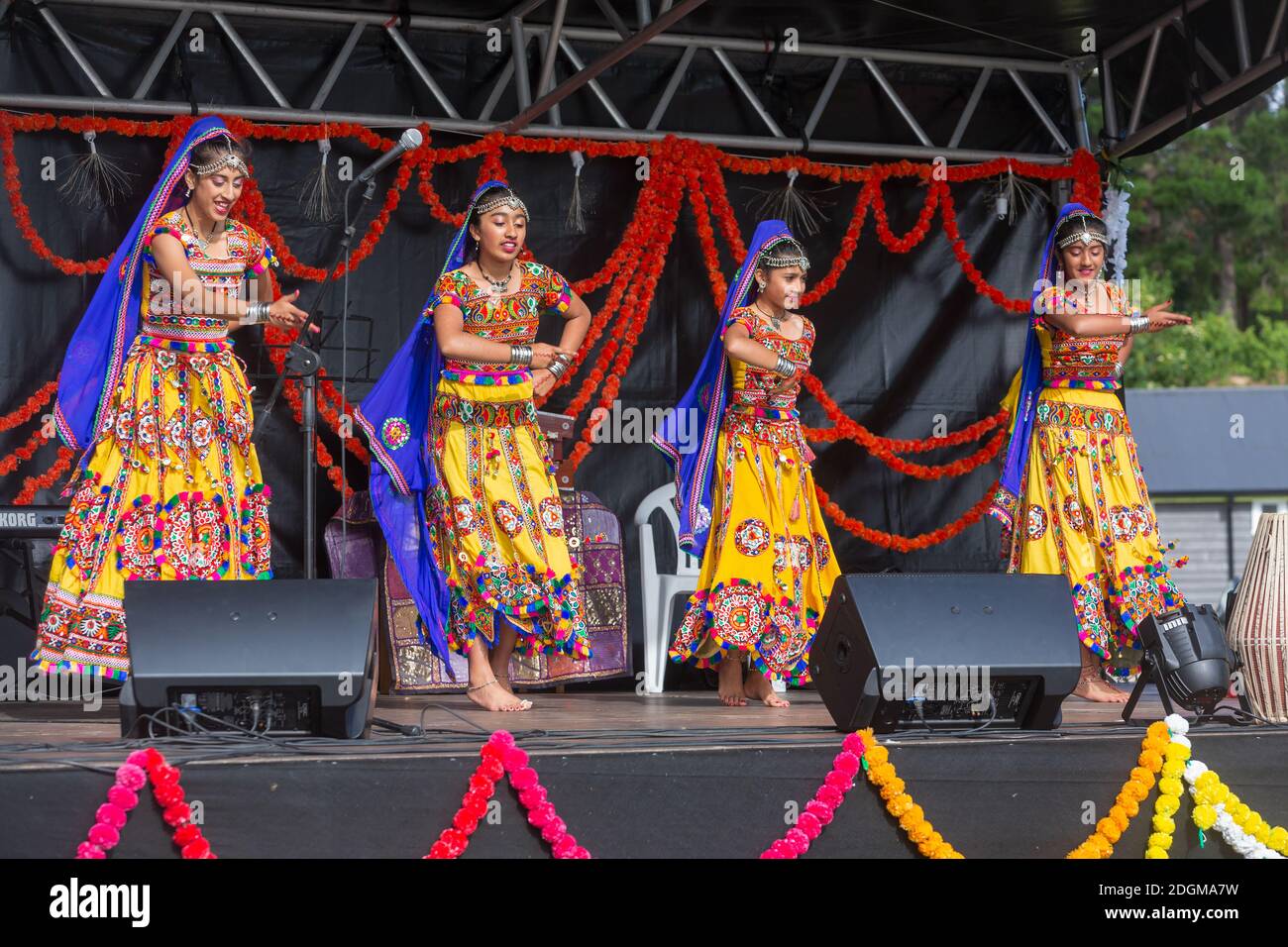 Group of Indian women in colorful saris dancing on stage during Diwali ...