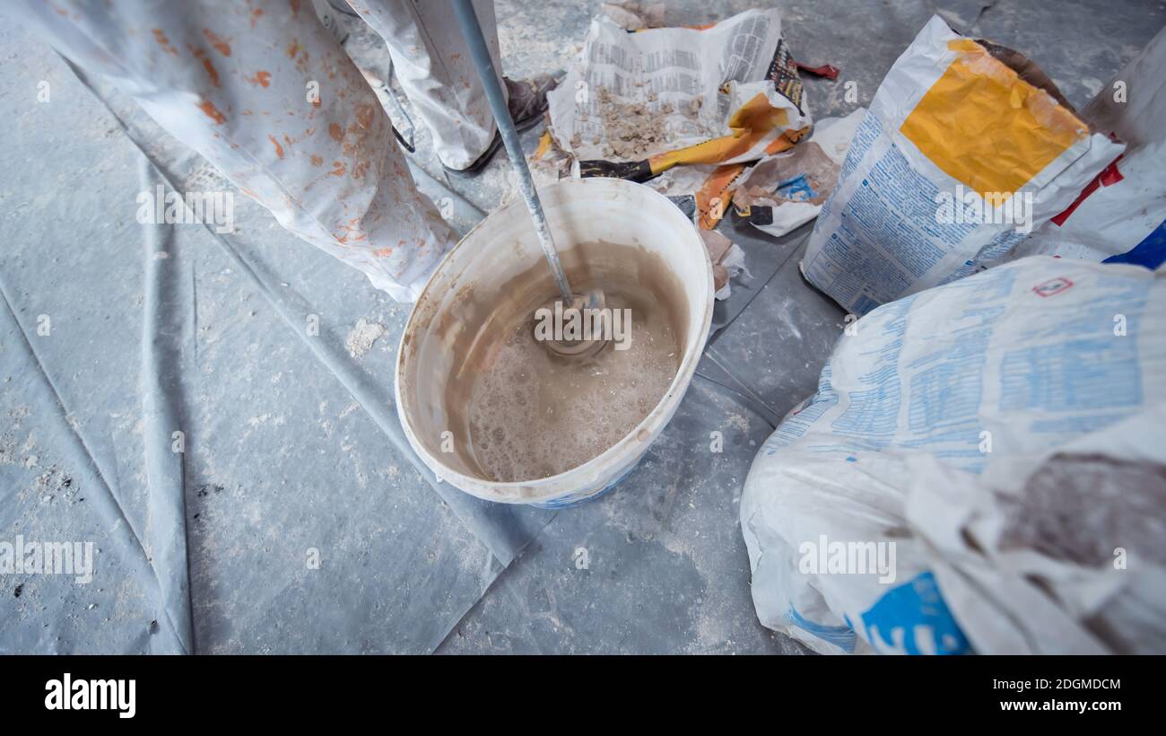 Construction worker mixing plaster in bucket Stock Photo - Alamy
