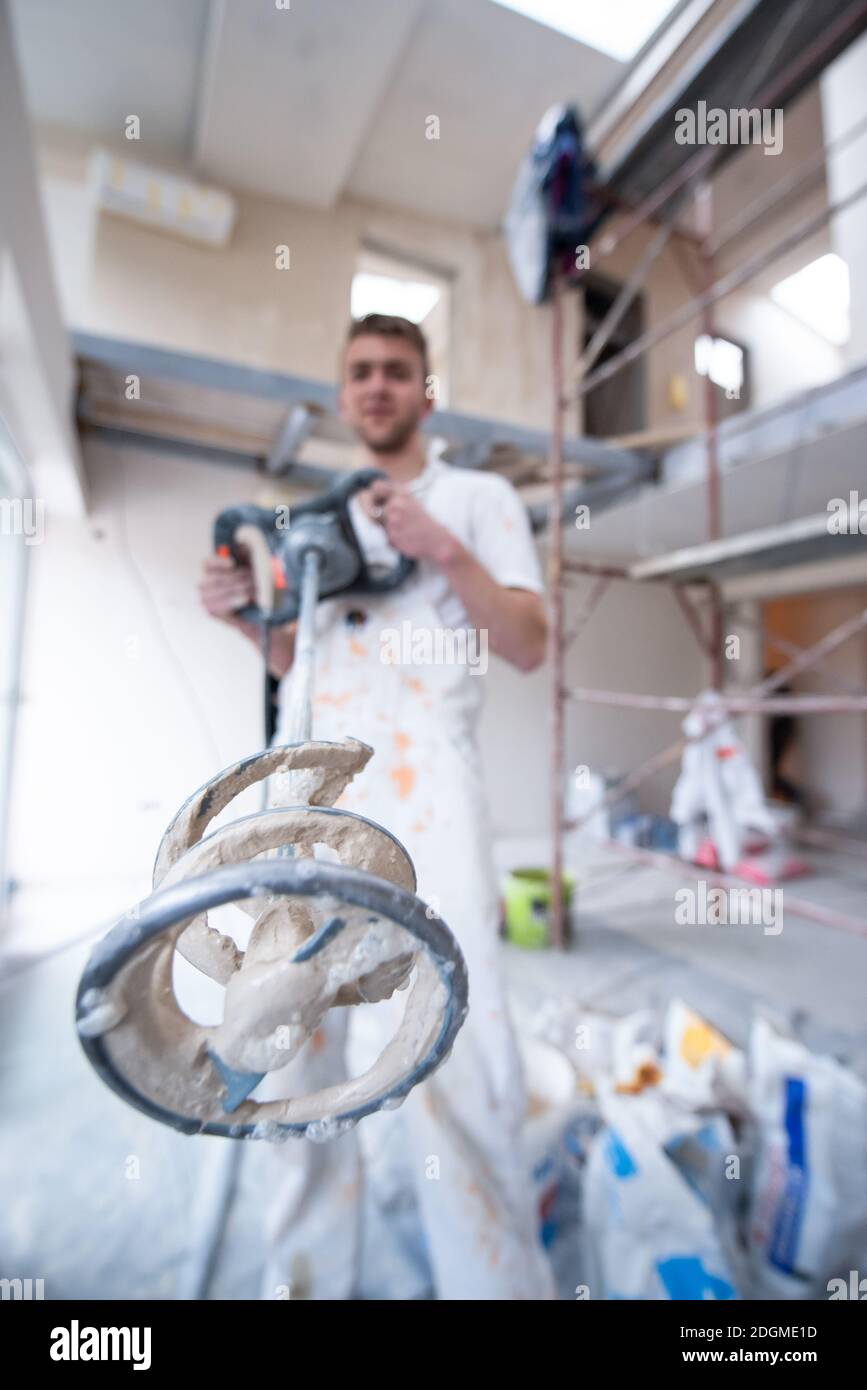 Construction worker mixing plaster in bucket Stock Photo - Alamy