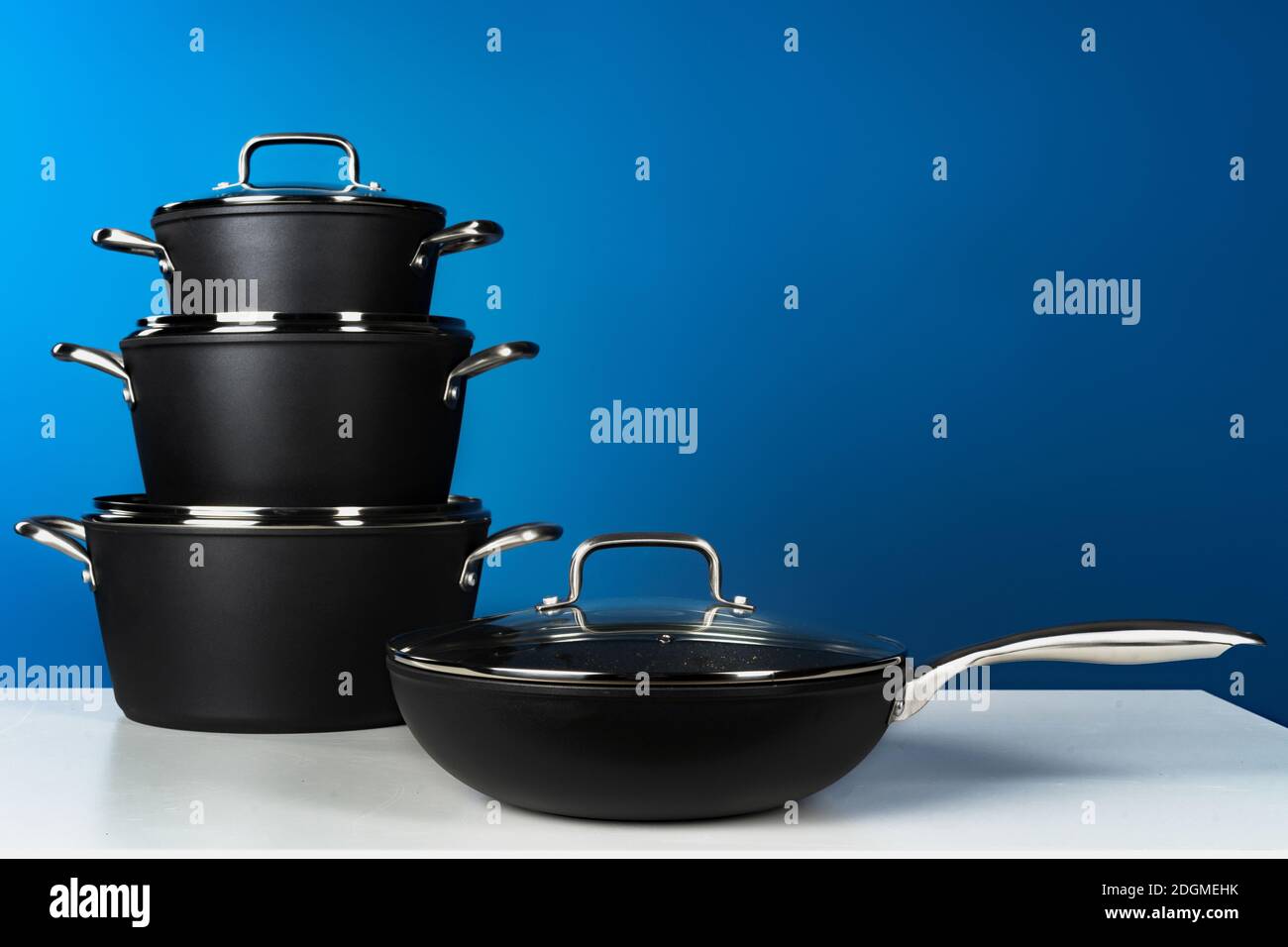 Set of black cookware against blue background Stock Photo - Alamy