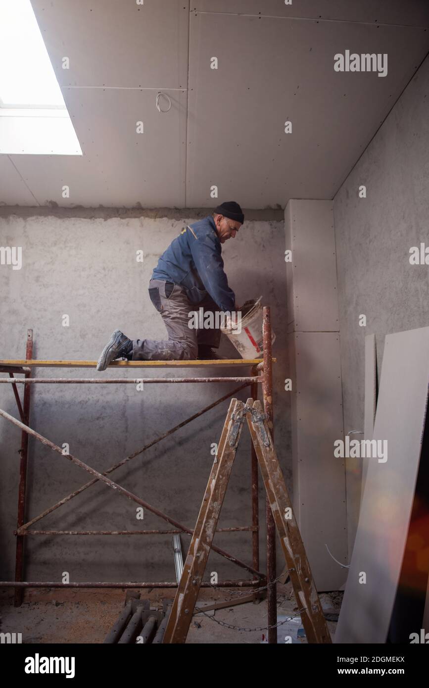 Construction worker plastering on gypsum ceiling Stock Photo - Alamy