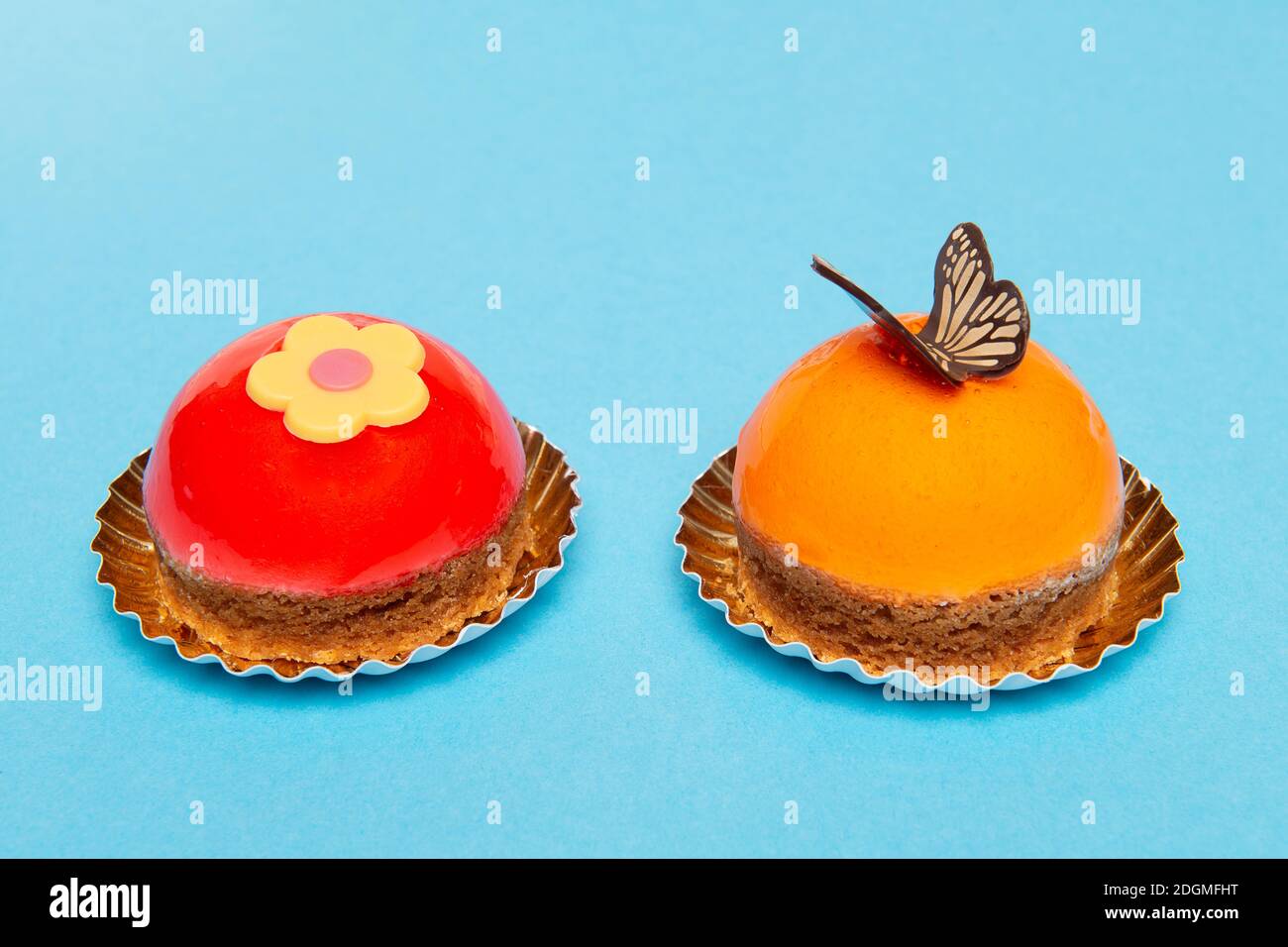 Two delicious looking small round cakes on a blue background with space ...