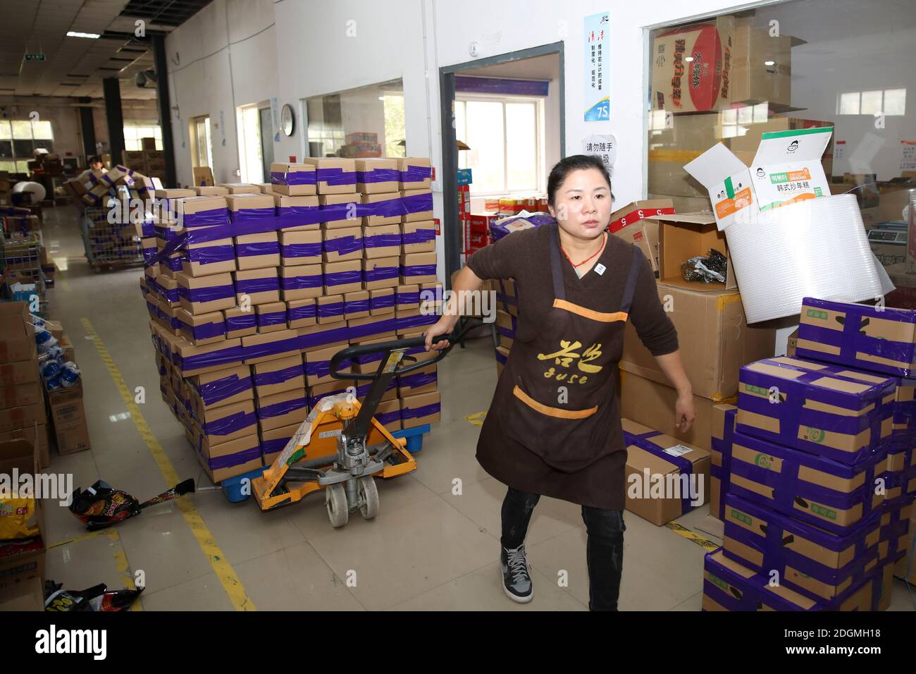 Staff sort and pack goods for deliveries in a logistics center of an e ...