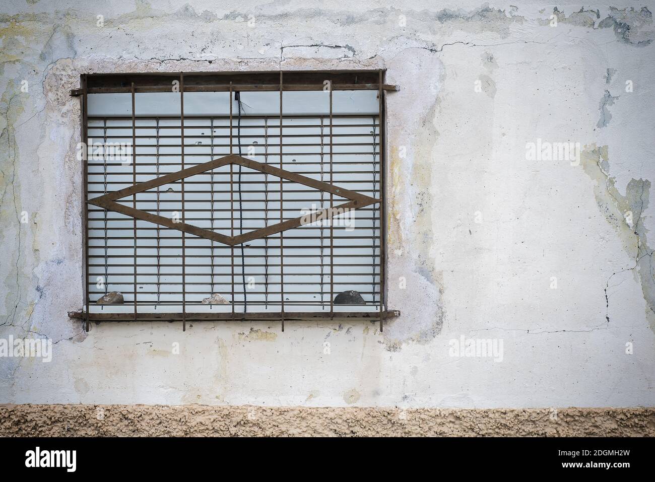 A view of a window with grating against a wall Stock Photo - Alamy
