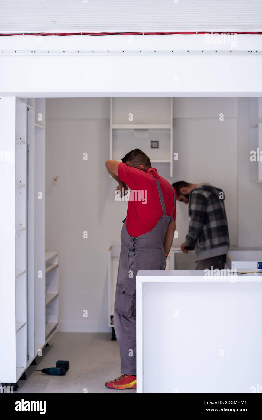 Workers installing a new kitchen Stock Photo - Alamy