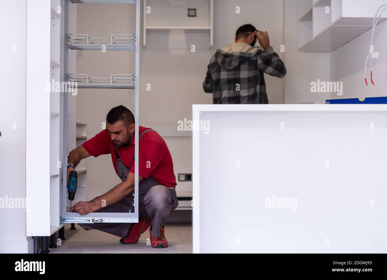 Workers installing a new kitchen Stock Photo - Alamy