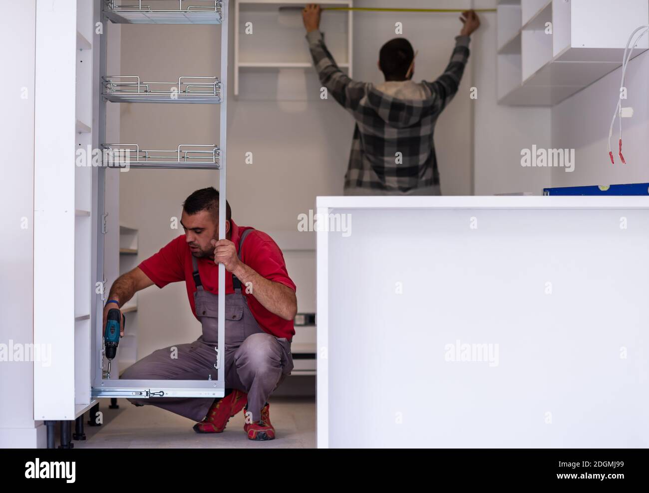Workers installing a new kitchen Stock Photo - Alamy