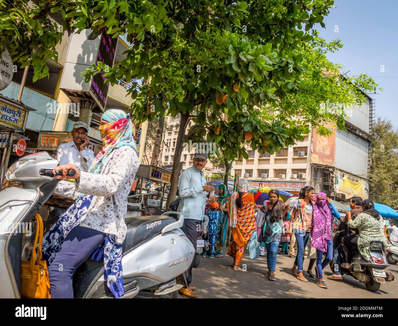 PUNE, INDIA - MARCH 14, 2019: Woman on moped on a busy street in Pune ...