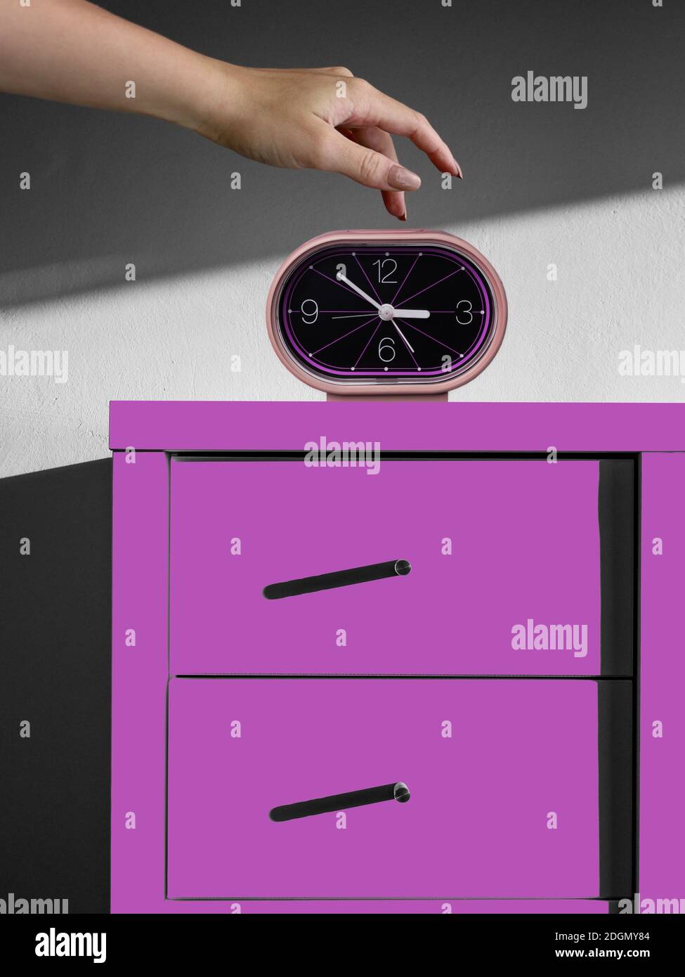 Female Hand Turning Off Analog Retro Alarm Clock On Violet Night Stand