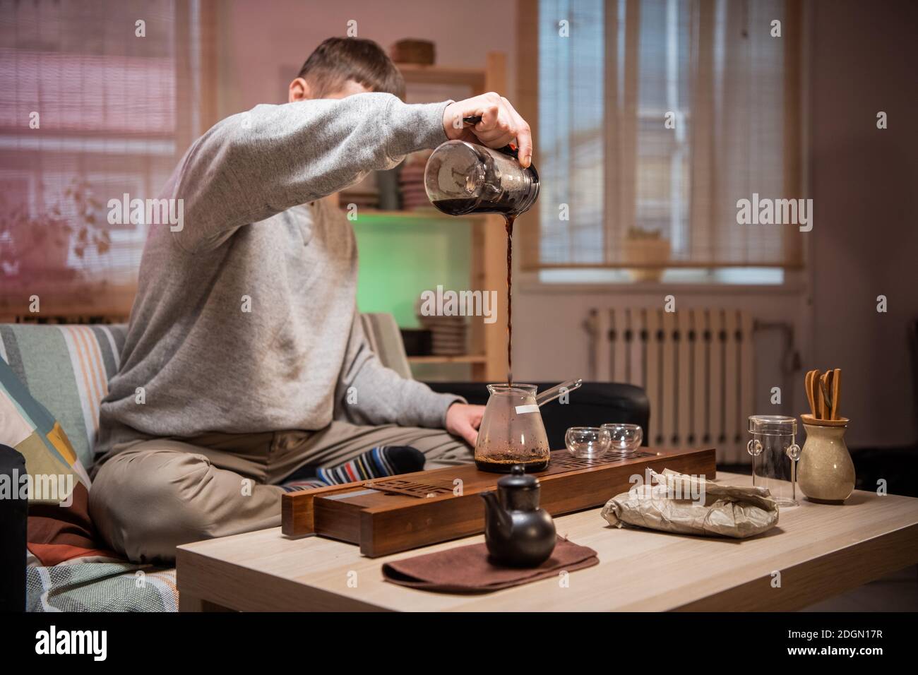 The process of brewing authentic japanese tea at home. A man pours hot ...