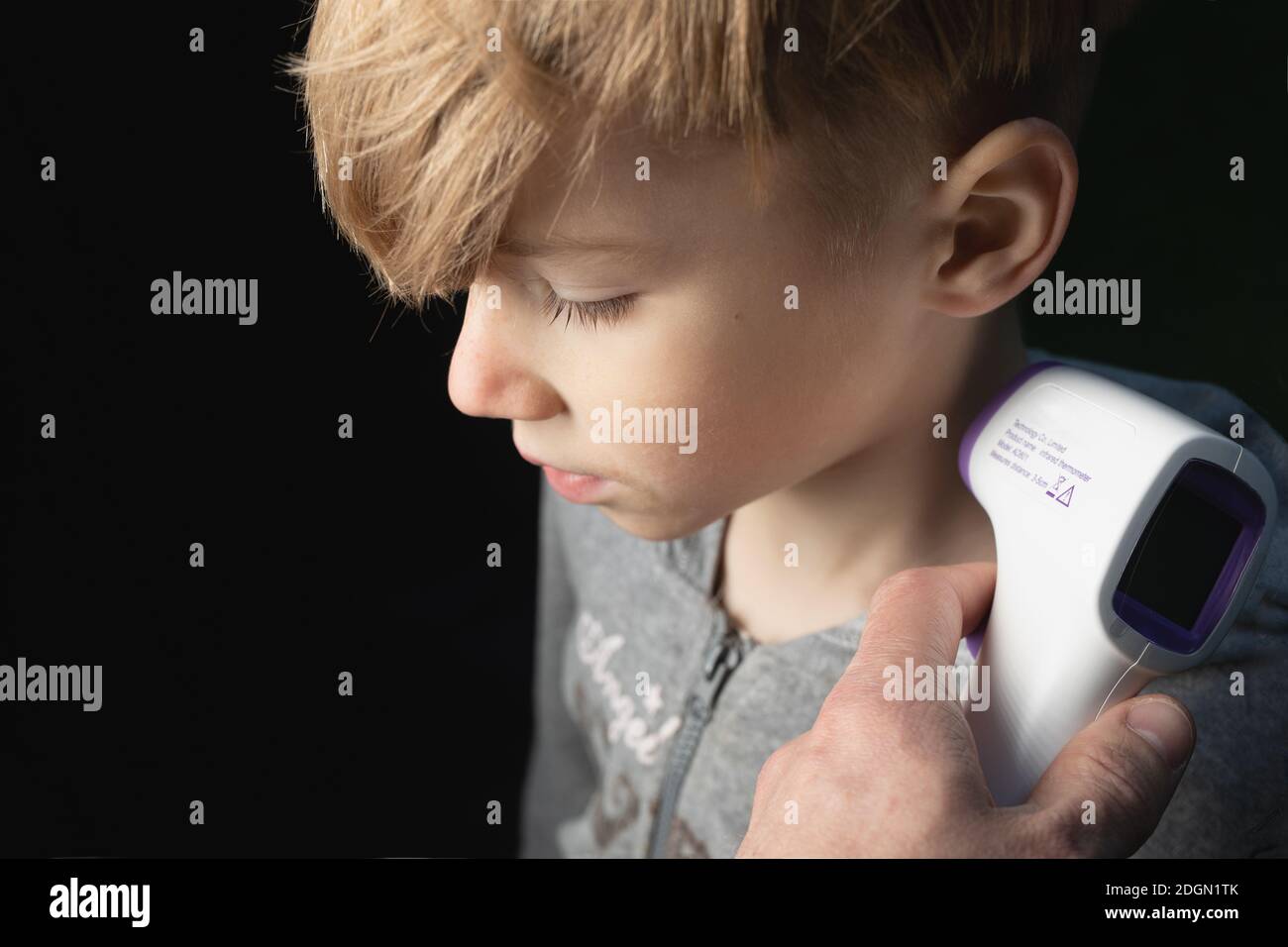 Measuring boy's temperature using non contact device infrared ...
