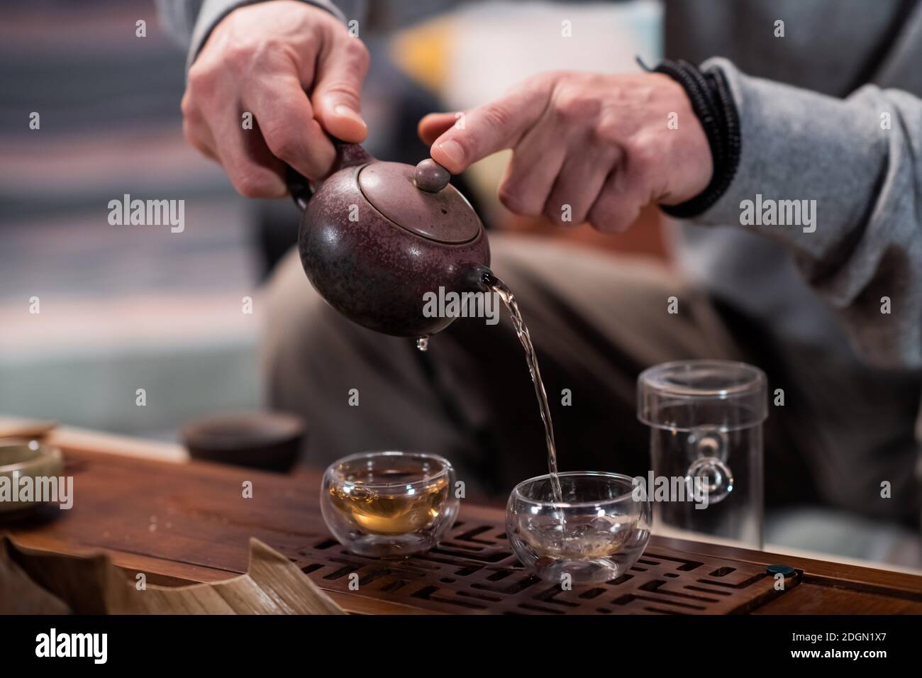 Close-up with the hands of a tea ceremony master in a tea shop, pouring ...
