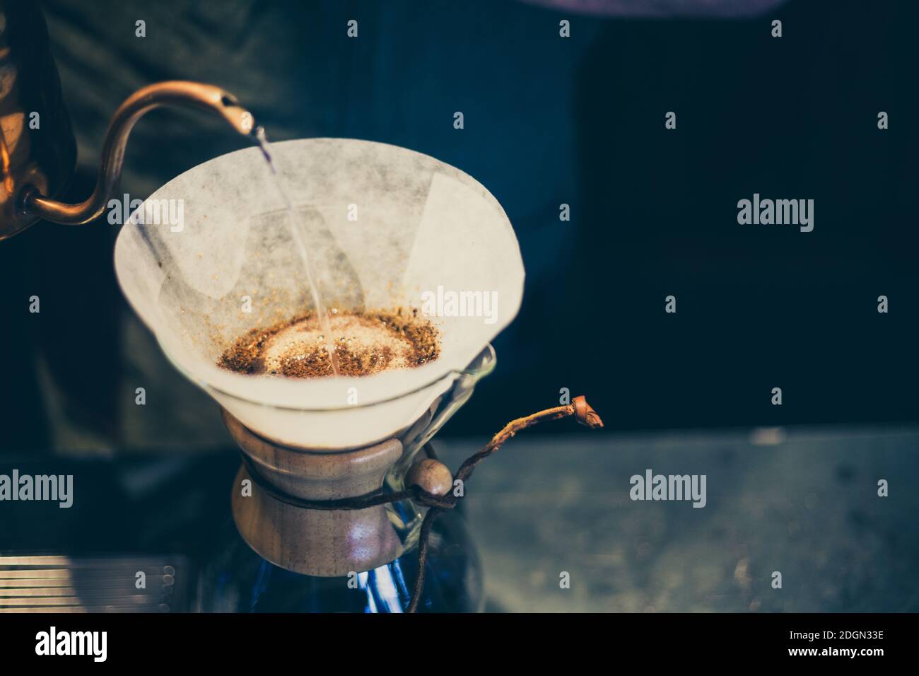 A closeup shot of water pouring into a coffee filter with ground bits ...