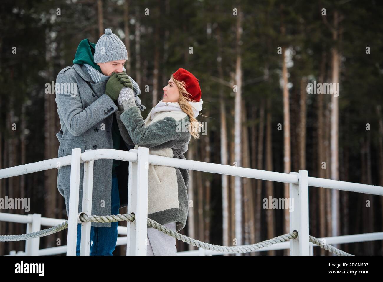 A young husband and wife stand on the bridge in an embrace against the ...