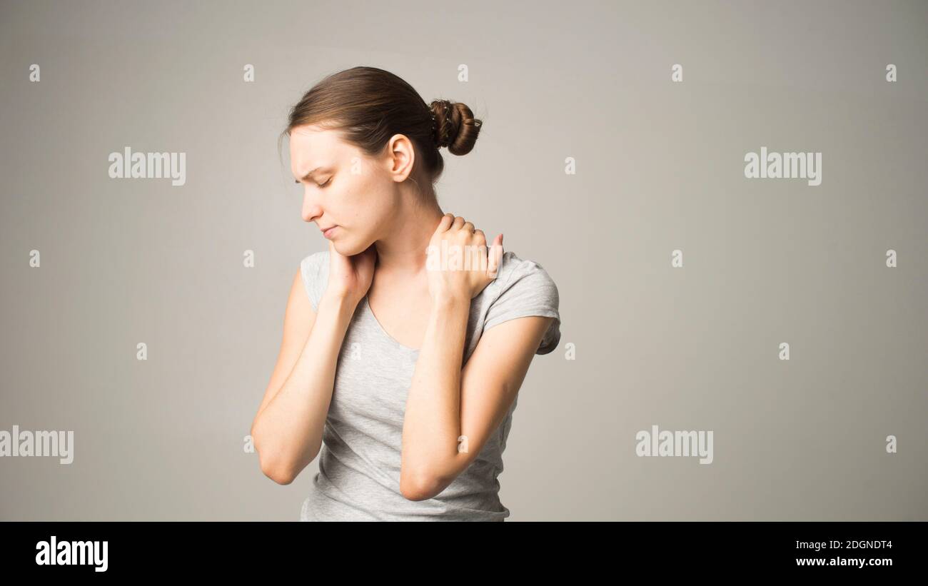 Tired woman feeling pain, massaging tense muscles Stock Photo - Alamy