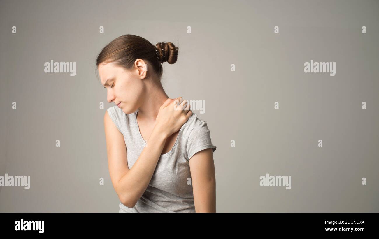 Tired woman feeling pain, massaging tense muscles Stock Photo - Alamy