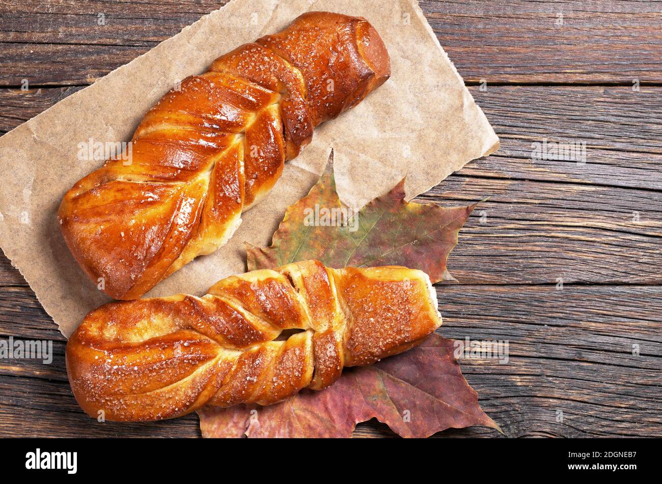 Two sweet braided buns on old wooden background, top view Stock Photo ...