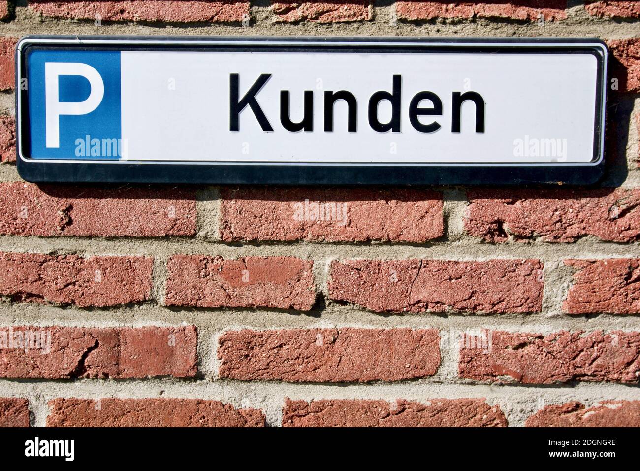 A closeup of a parking nameplate with the writing "Kunden - Customers ...