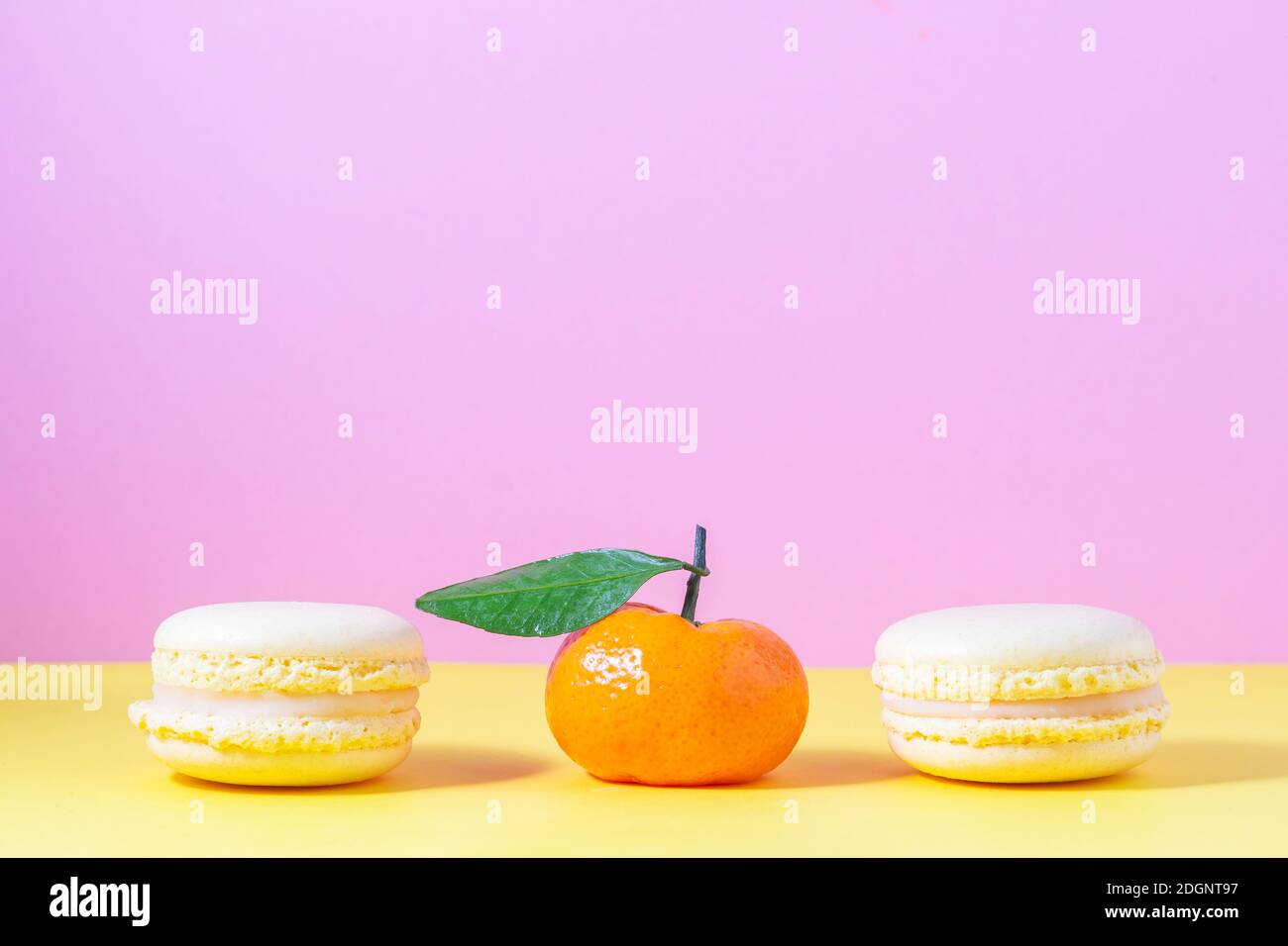 Yellow french macaroon pastries with lemon cream on yellow and pink ...
