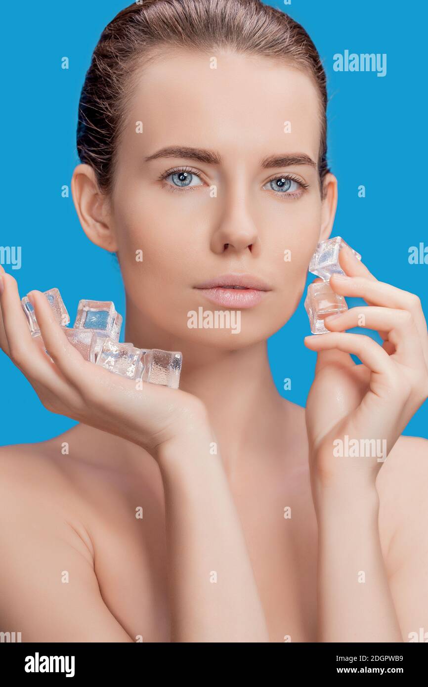 Beautiful woman applying ice cube treatment on blue background Stock ...