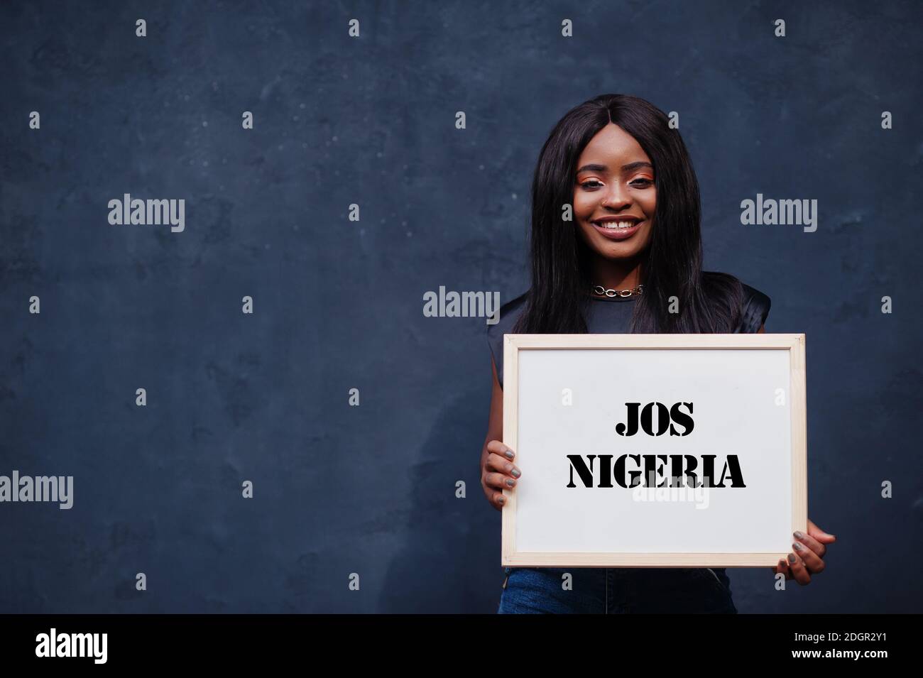 African woman hold white board with Jos Nigeria inscription. Most ...
