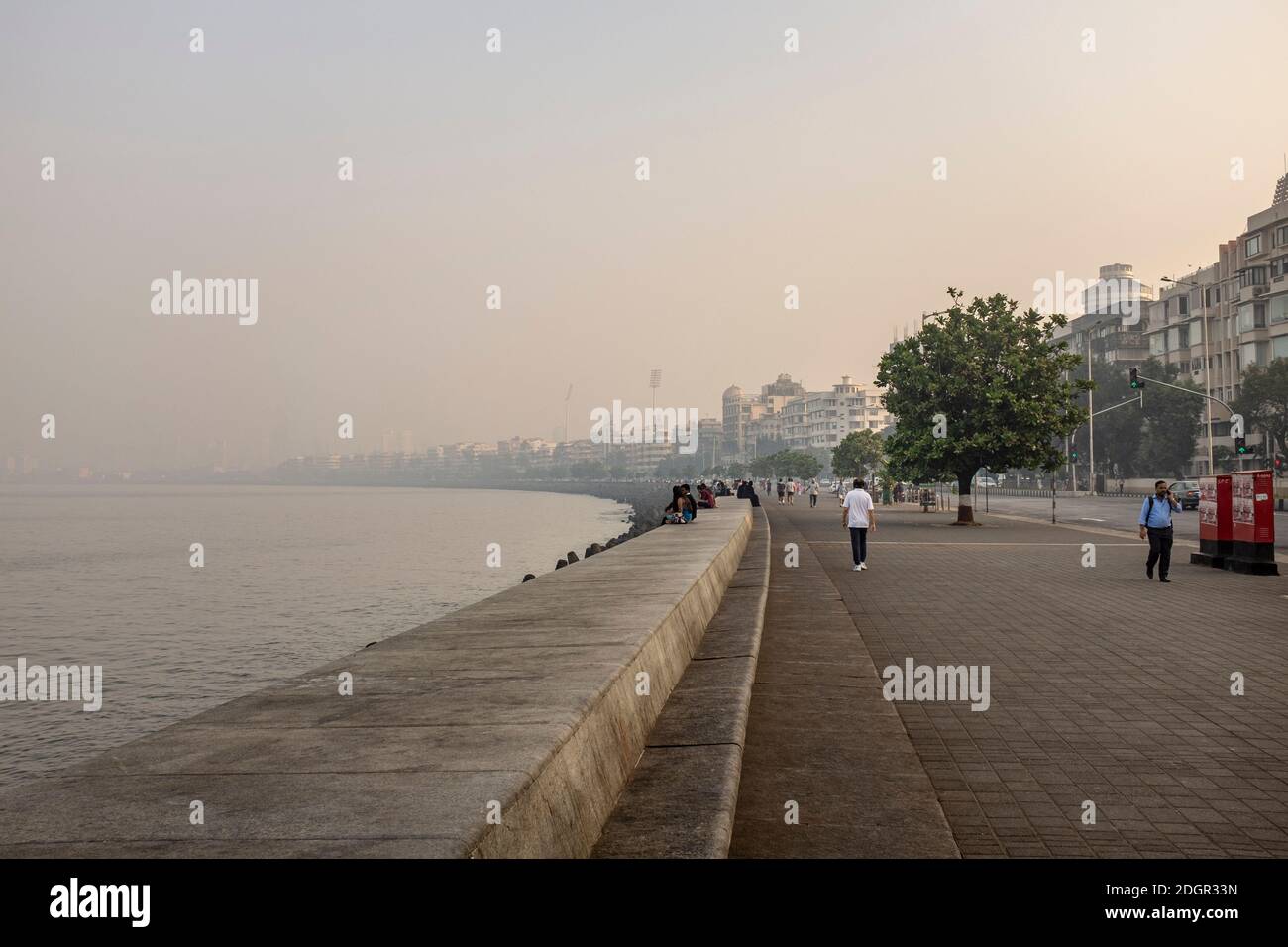 Locals exercising along the promenade at Marine Drive, on a smoggy day ...