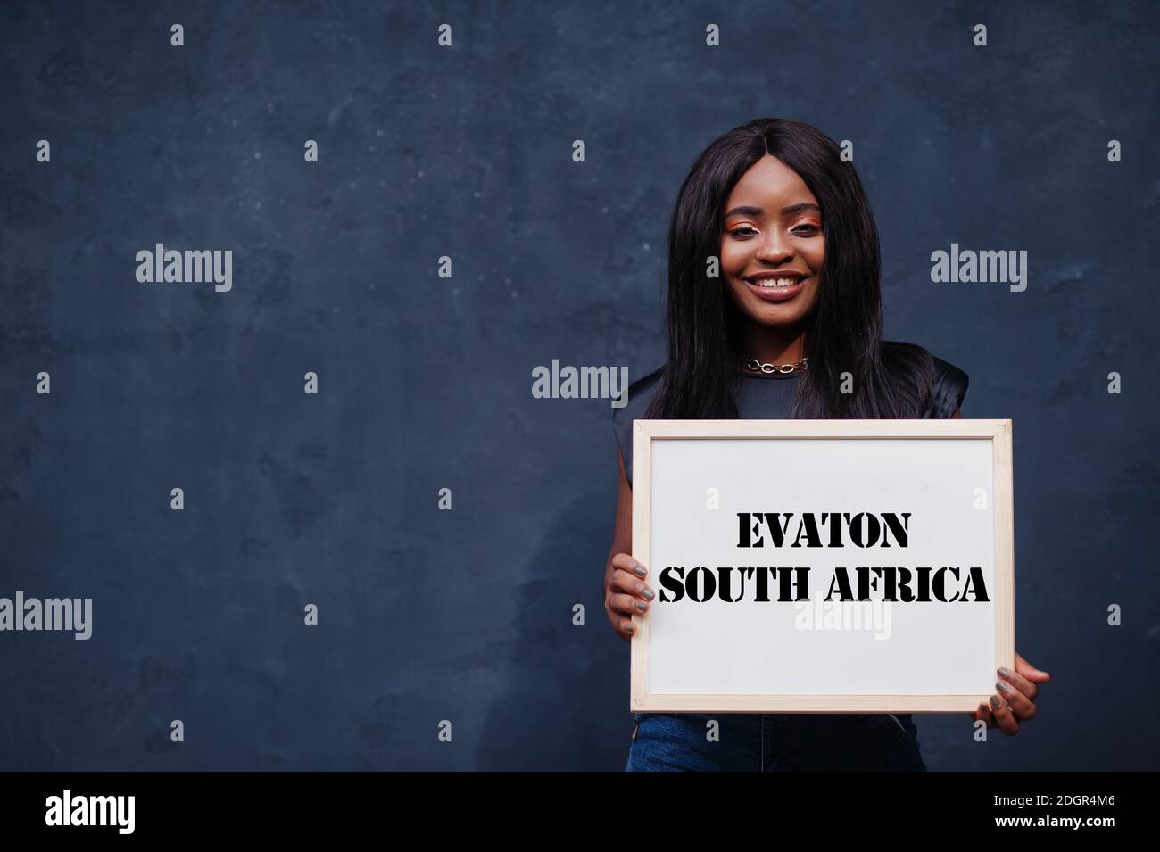 African woman hold white board with Evaton South Africa inscription. Most populous city in ...