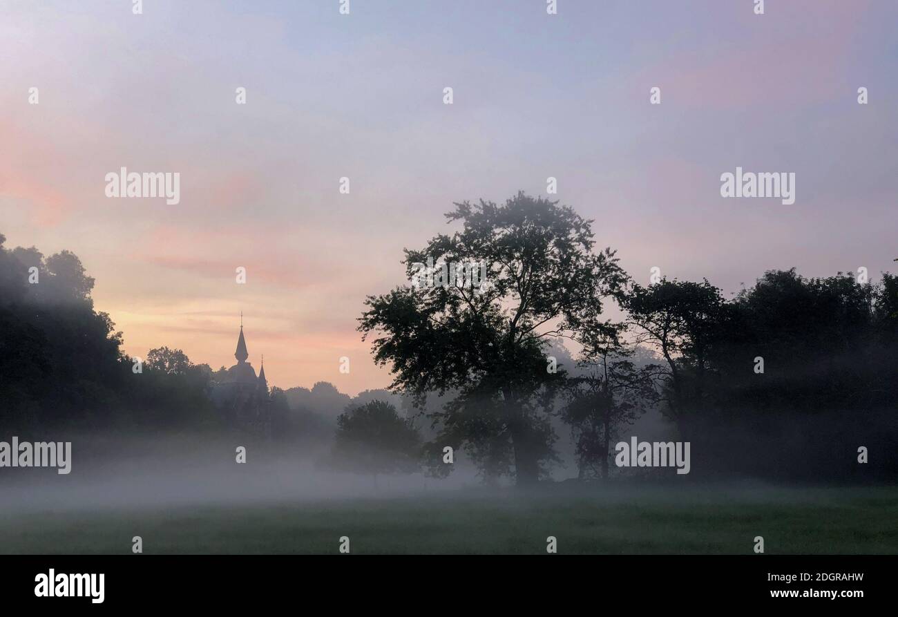 Colorful glowing sunrise over a distant castle Stock Photo - Alamy