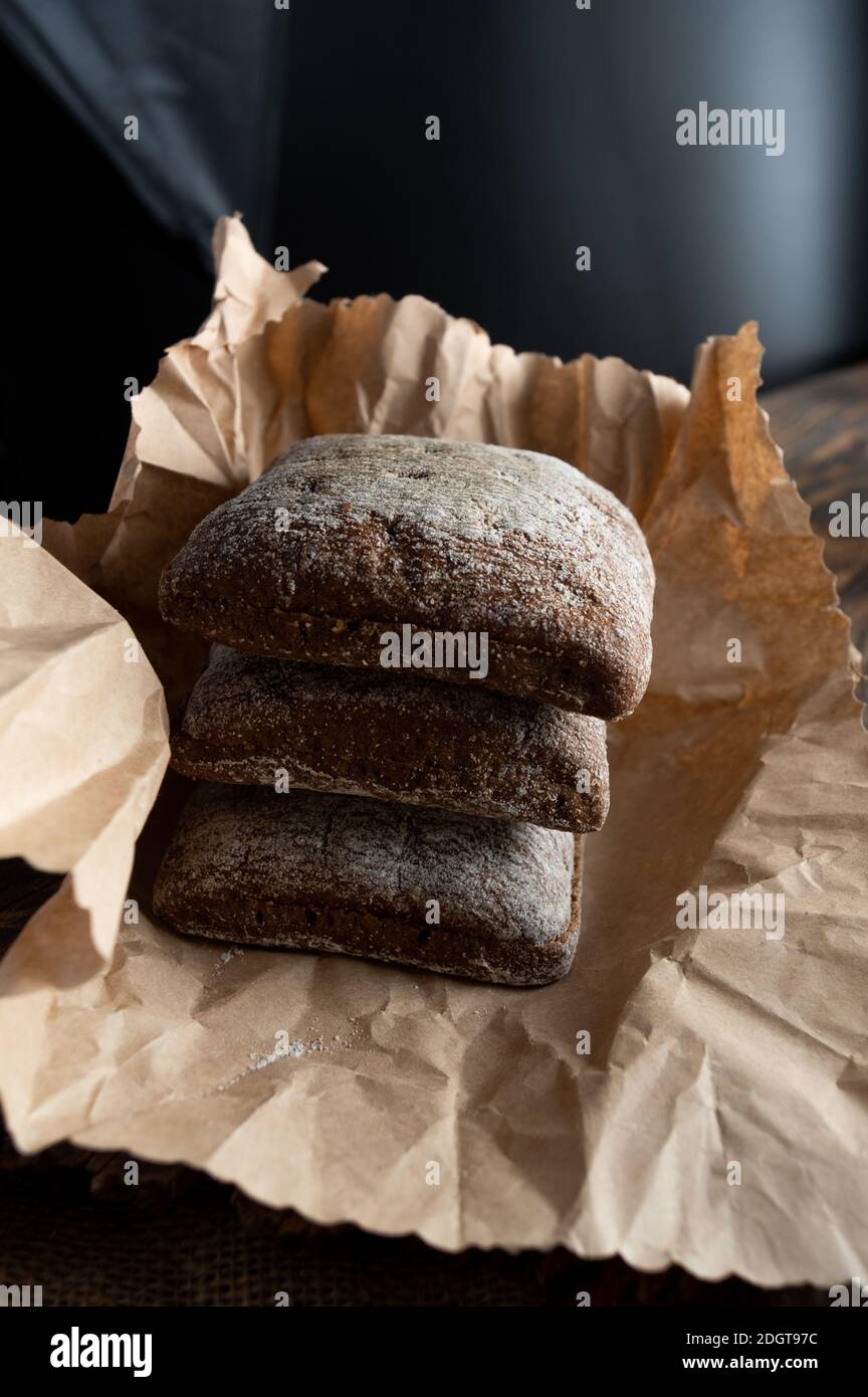 Dark dough buns. Bread in craft paper. Low key. Dark mood. Vertical ...
