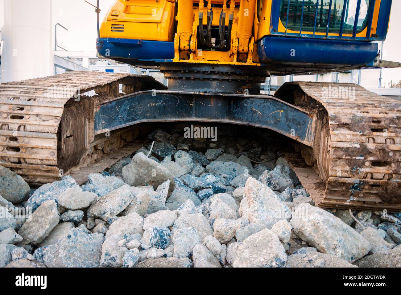 Excavator clearing up concrete waste from a concrete structure in an ...