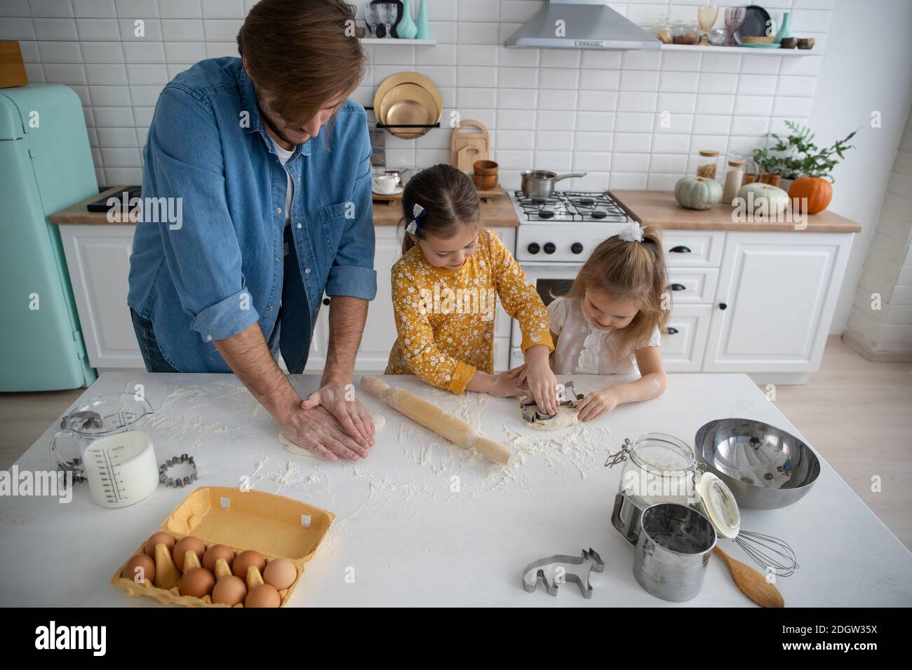 smiling father and daughters baking in the kitchen and having fun Stock ...
