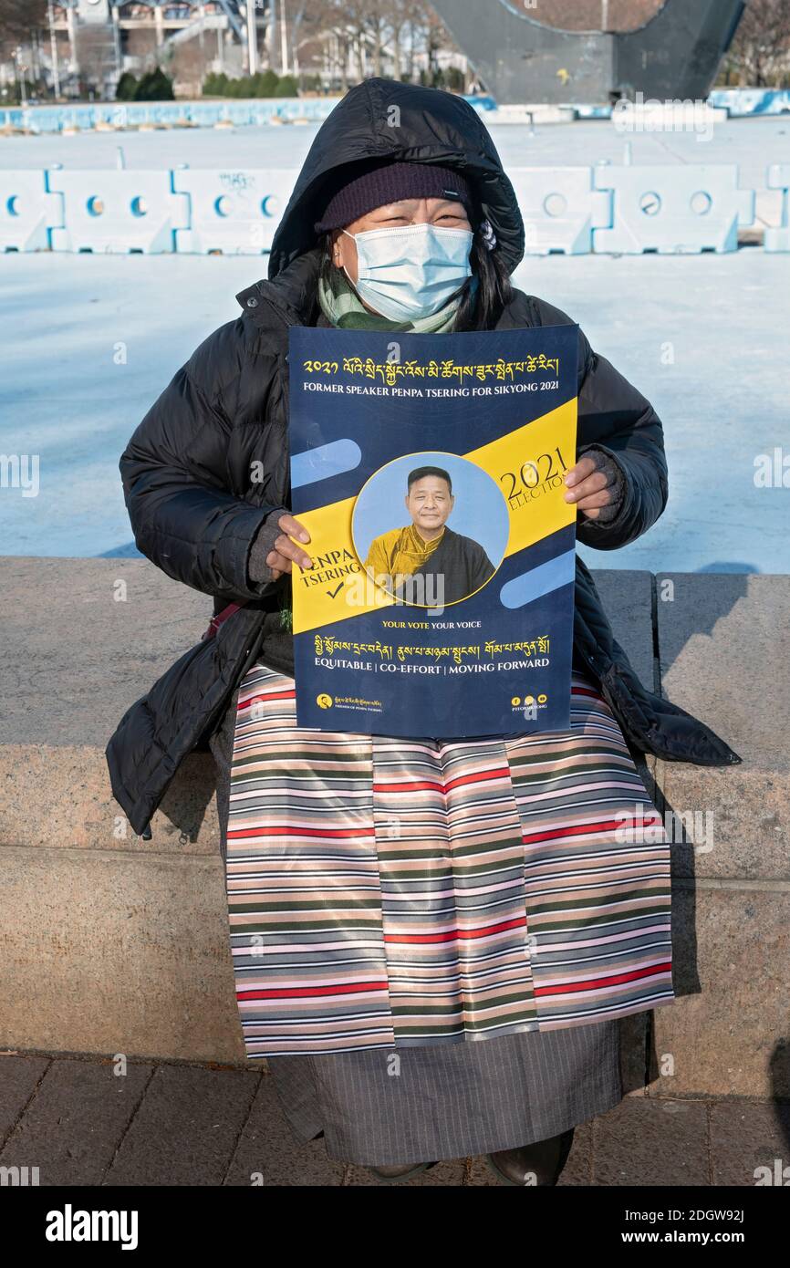 A Tibetan American woman holds a poster supporting the candidacy of ...