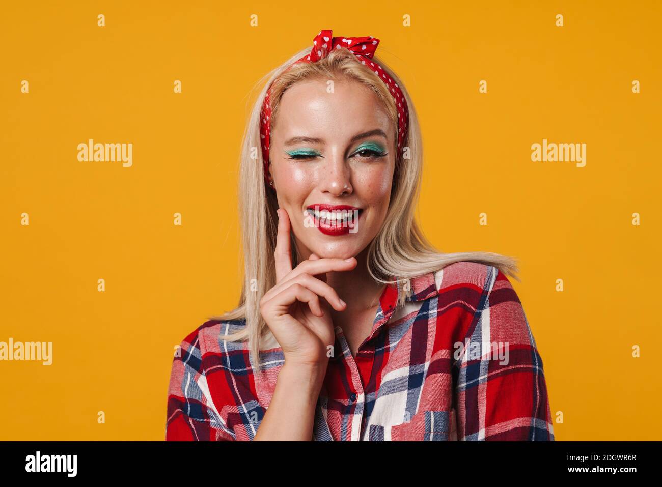 Image of joyful blonde pinup girl smiling and winking at camera ...
